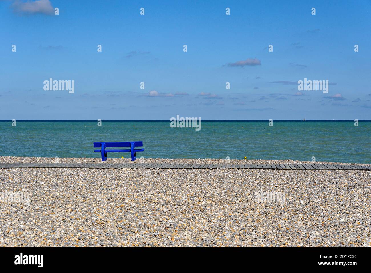 In "Baie-de-Somme" France, a blue bench on a pebble beach facing the ...