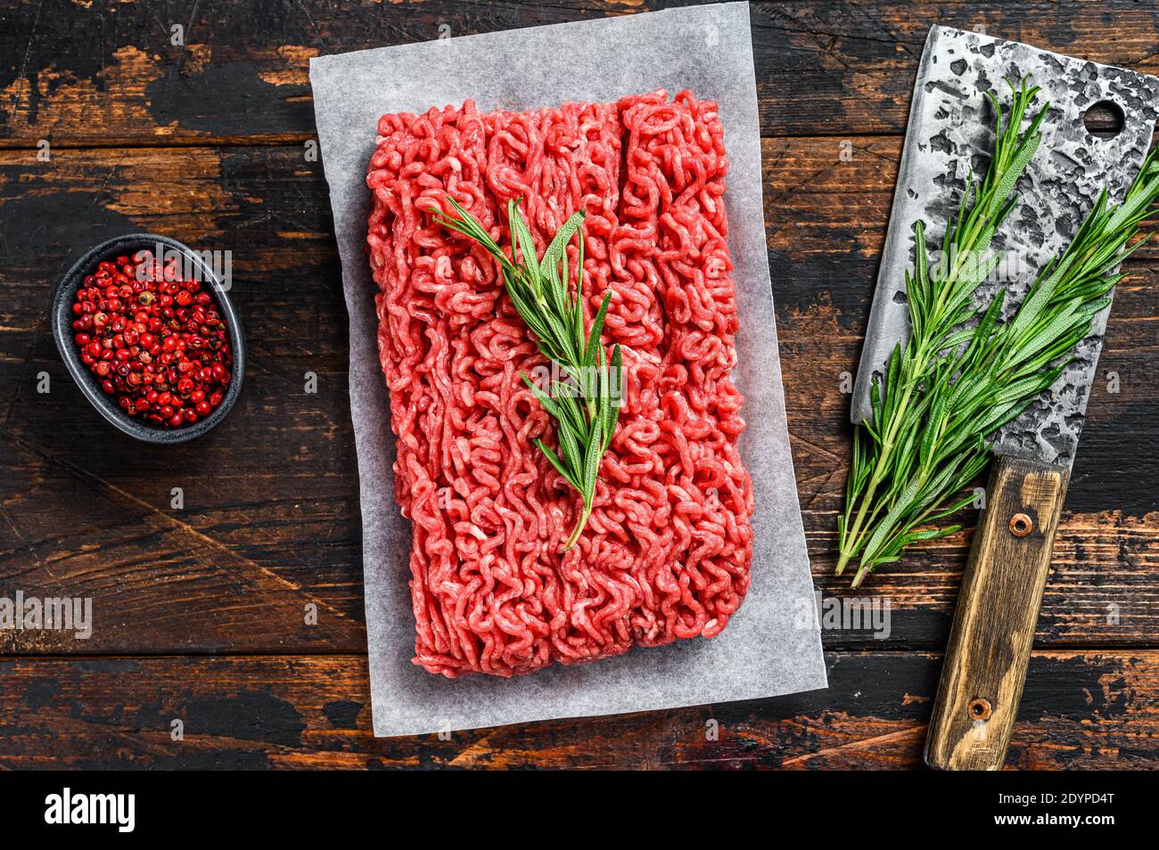 Raw forcemeat beef, ground meat on butcher paper. Dark wooden ...