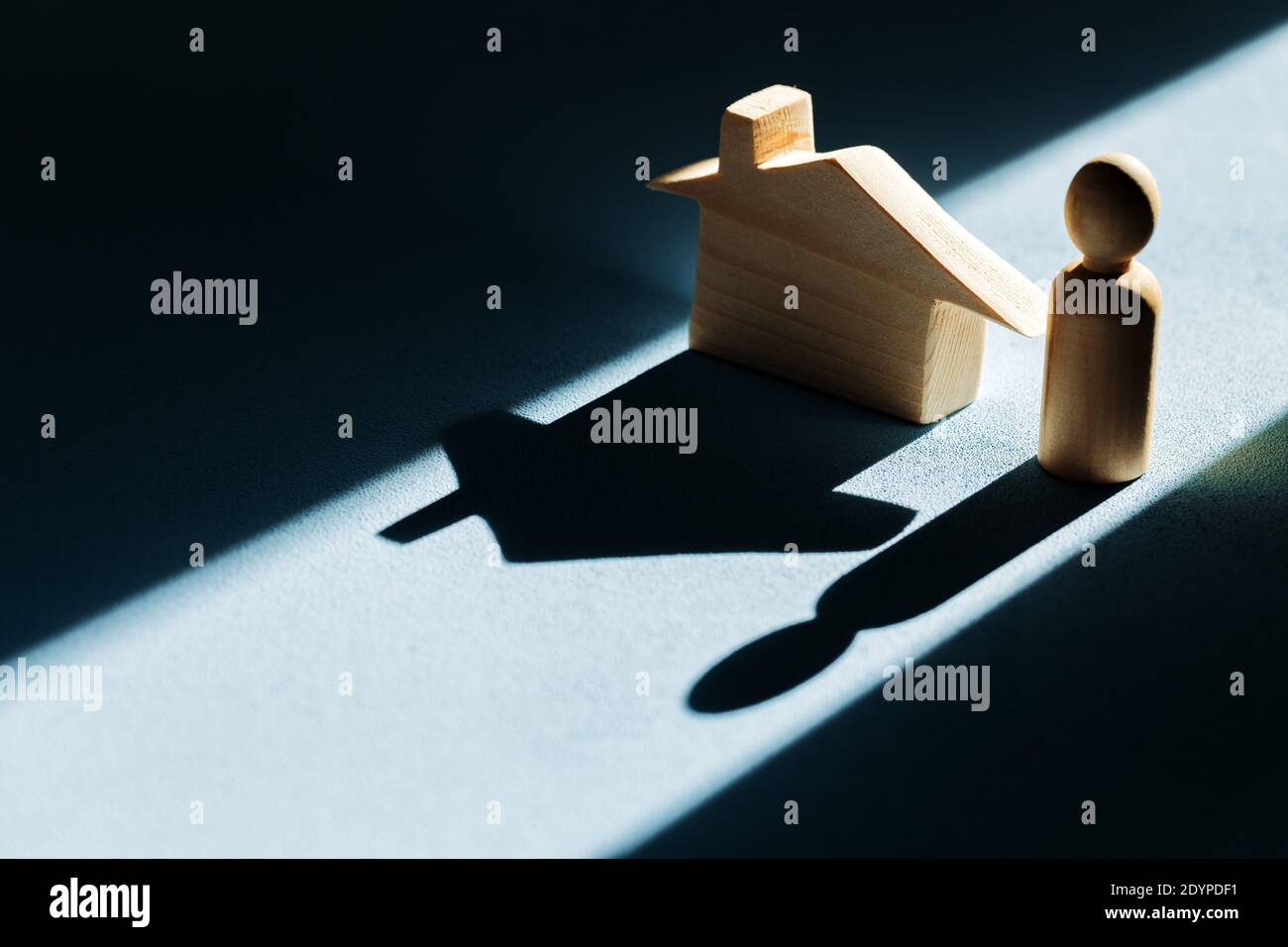 Miniature wooden house with shadows on blue background Stock Photo - Alamy