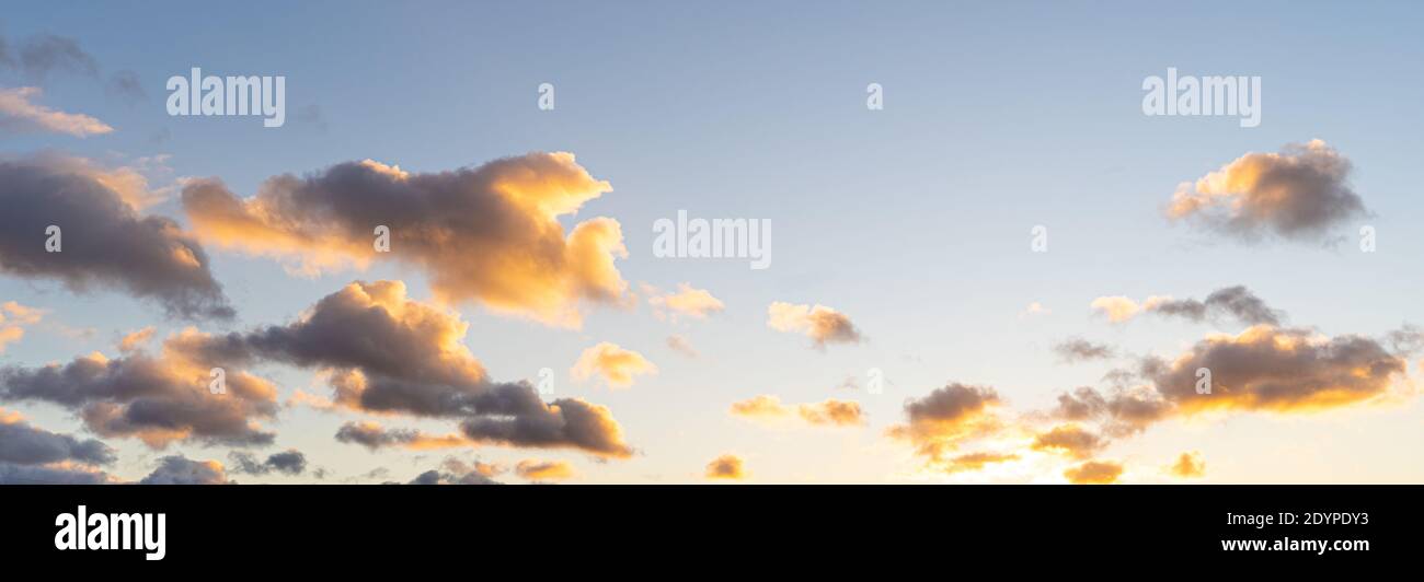 Cumulus sunset clouds with sun setting down Stock Photo - Alamy