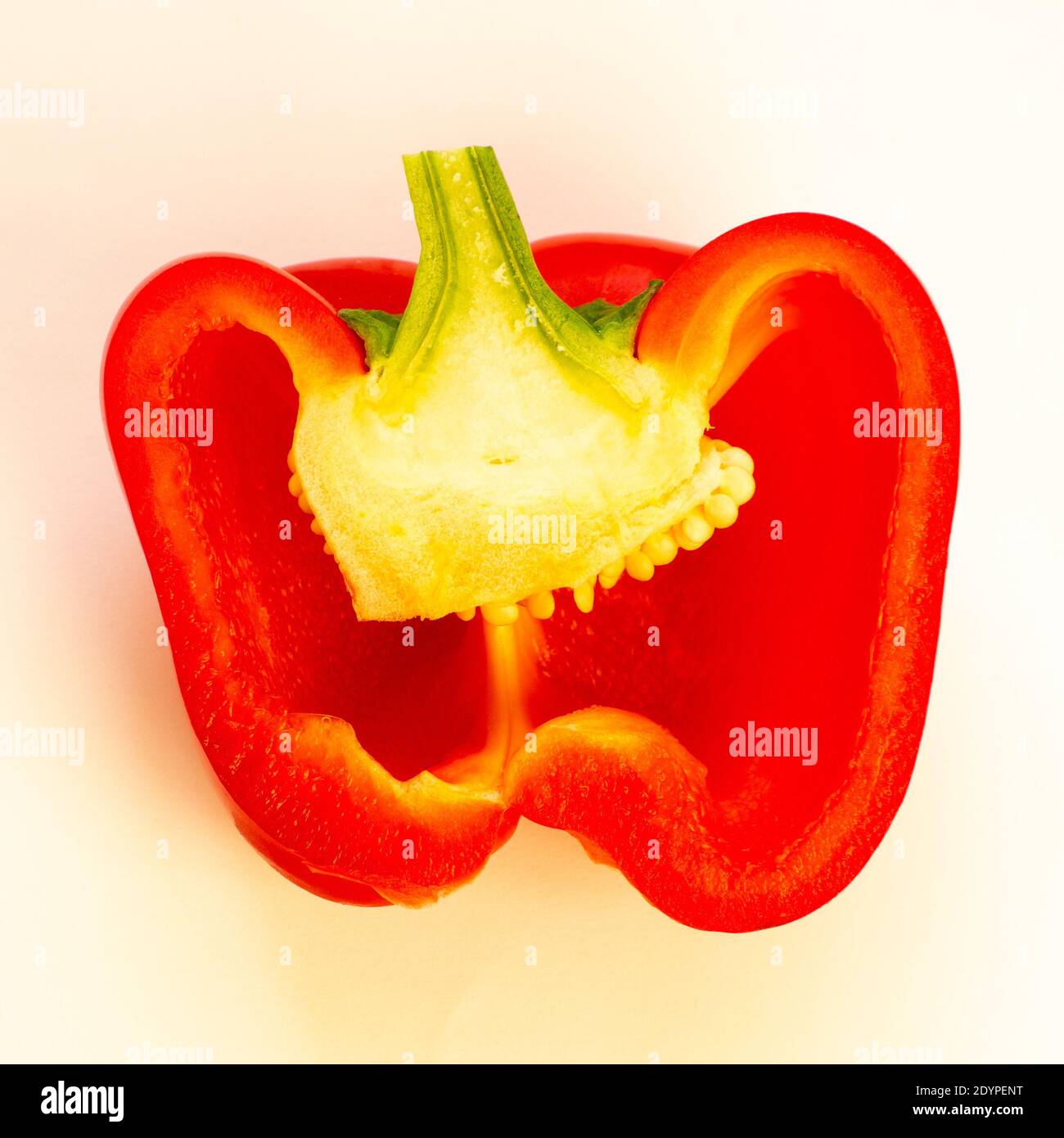 Cut fresh red bell pepper or capsicum with seeds set on white ...
