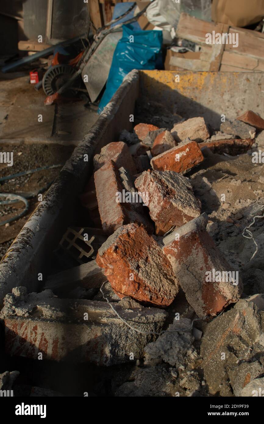 Bricks from demolition in container. Container with rubbish ...