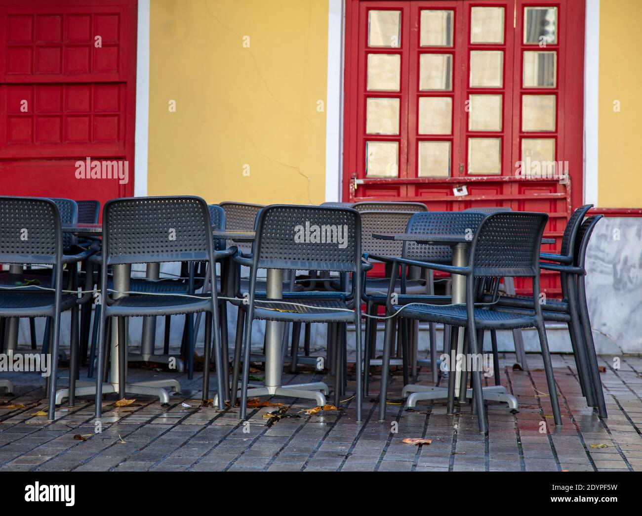 Restaurant cafe tables and seats tied with metal string in front of ...