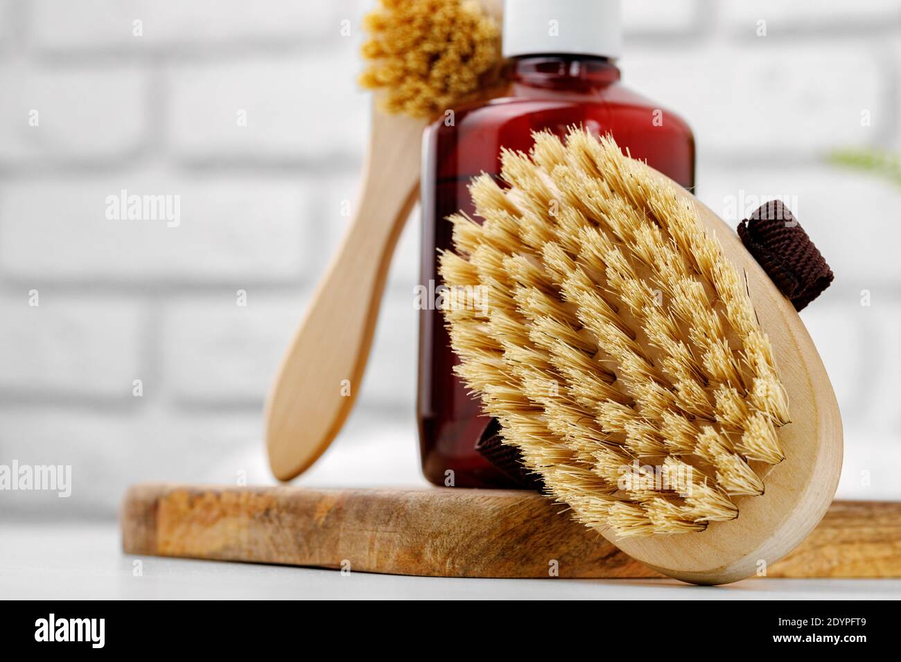 Liquid soap container and massage brush in bathroom Stock Photo - Alamy