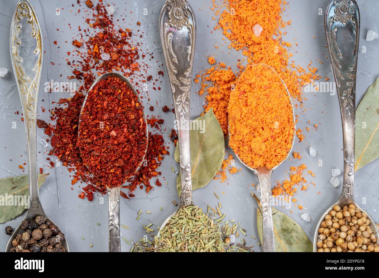 various spices in metal silver spoons with large crystals salt Stock ...