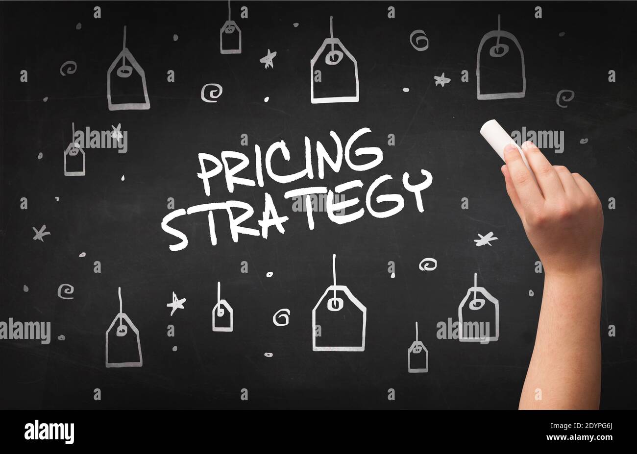 Hand drawing PRICING STRATEGY inscription with white chalk on ...