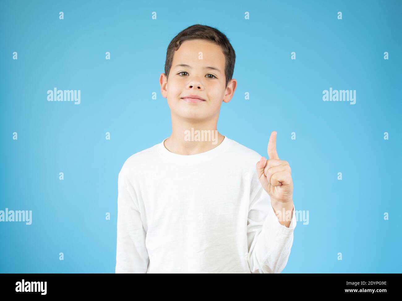 Portrait of cheerful boy with good idea - isolated over blue background ...