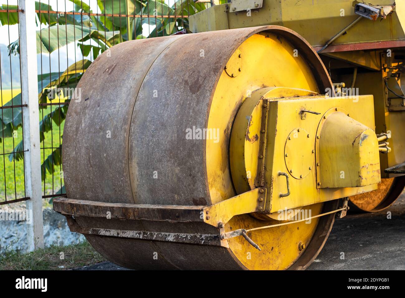 Old yellow road roller front wheel close view Stock Photo - Alamy
