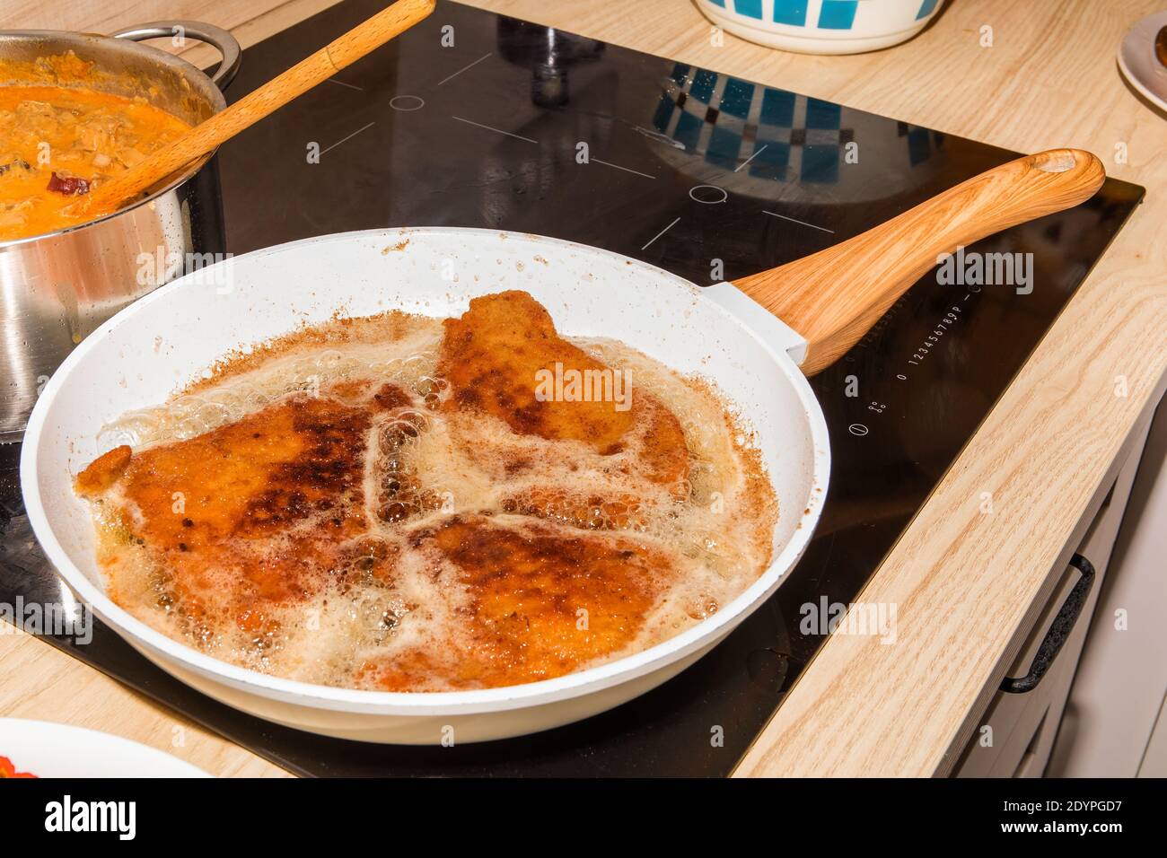 Wiener Schnitzel, frying in oil in a pan. Top view. Homemade ...