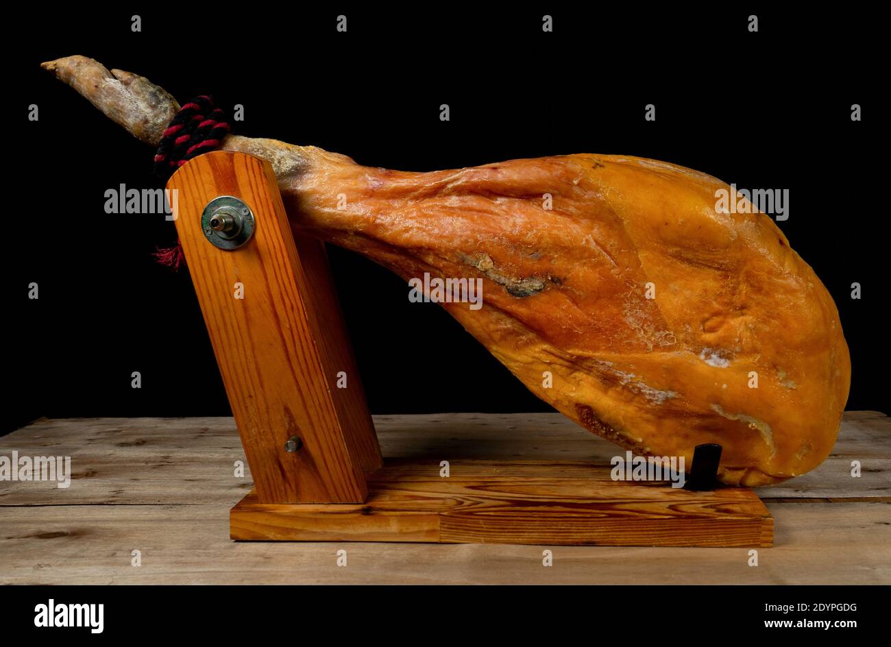 Detail of ham placed in a wooden ham holder ready to be cut. Exquisite ...