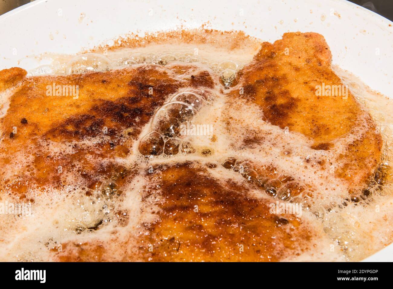 Wiener Schnitzel, frying in oil in a pan. Top view. Homemade ...