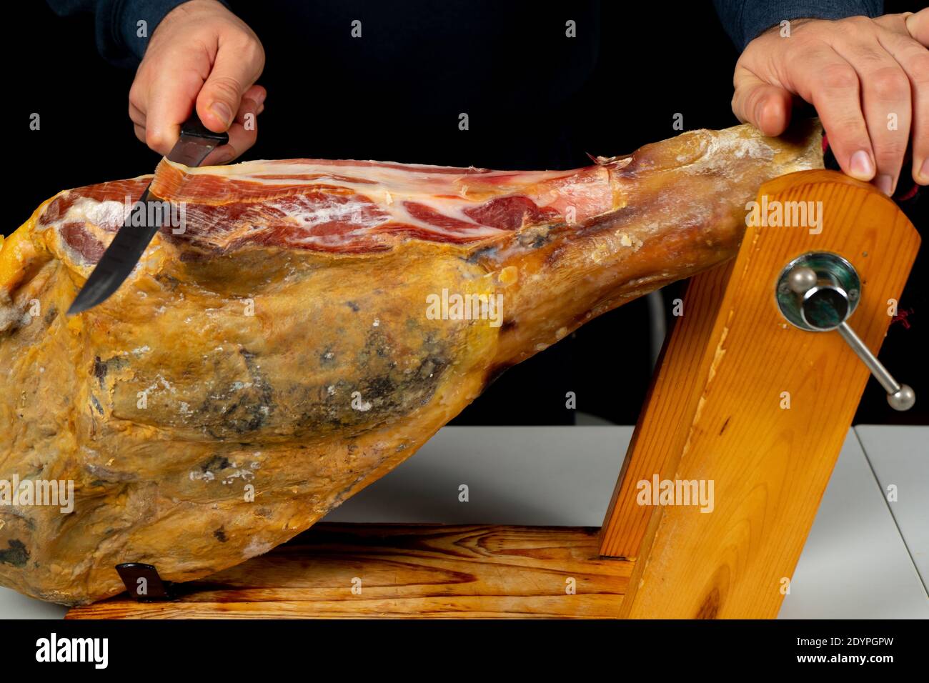 Detail of ham placed in a wooden ham holder ready to be cut. Exquisite ...