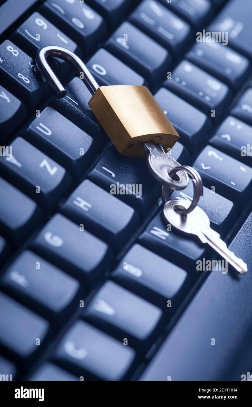 Unlocked metal padlock with keys on blue computer keyboard. Data and ...