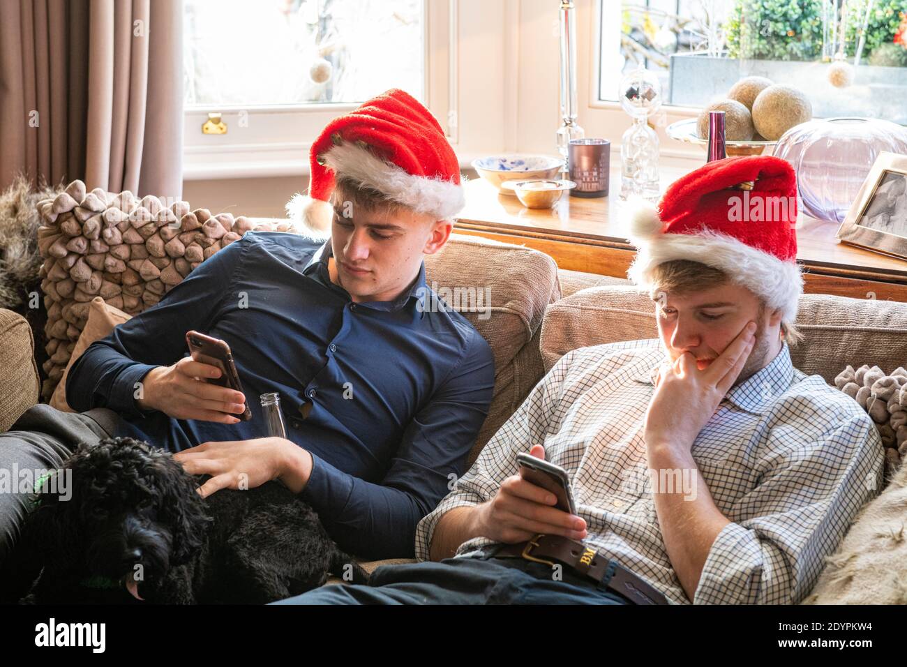 Two boys at Christmas in hats look at their mobile phones Stock Photo ...