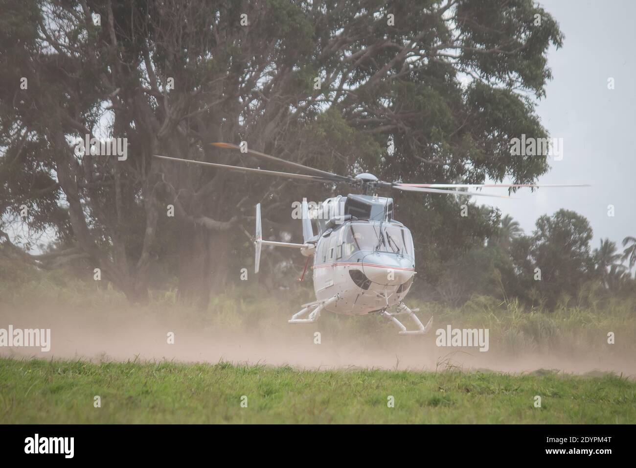 Helicopter landing in open field in Africa, delivering humanitarian ...