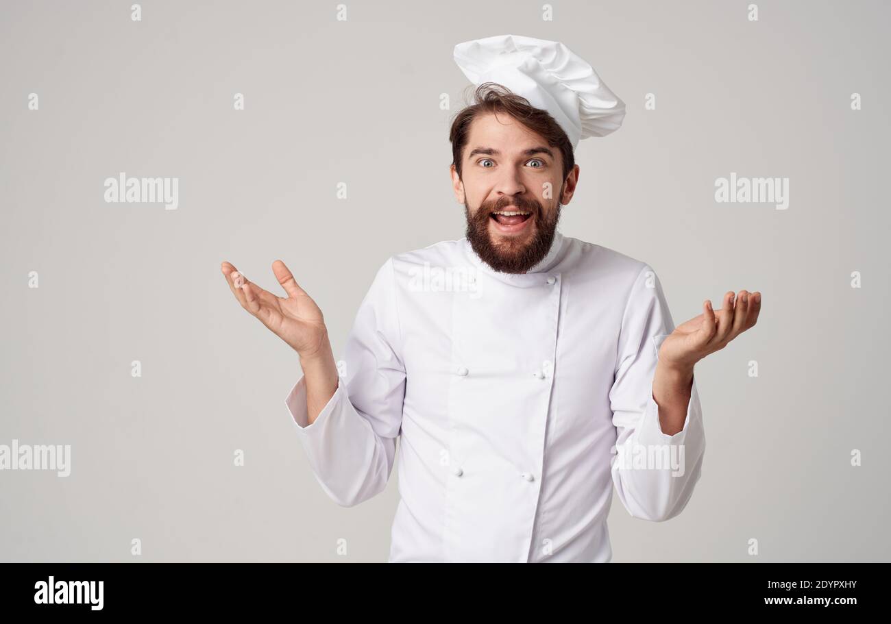 The professional chef gestures with his hands on a light background ...