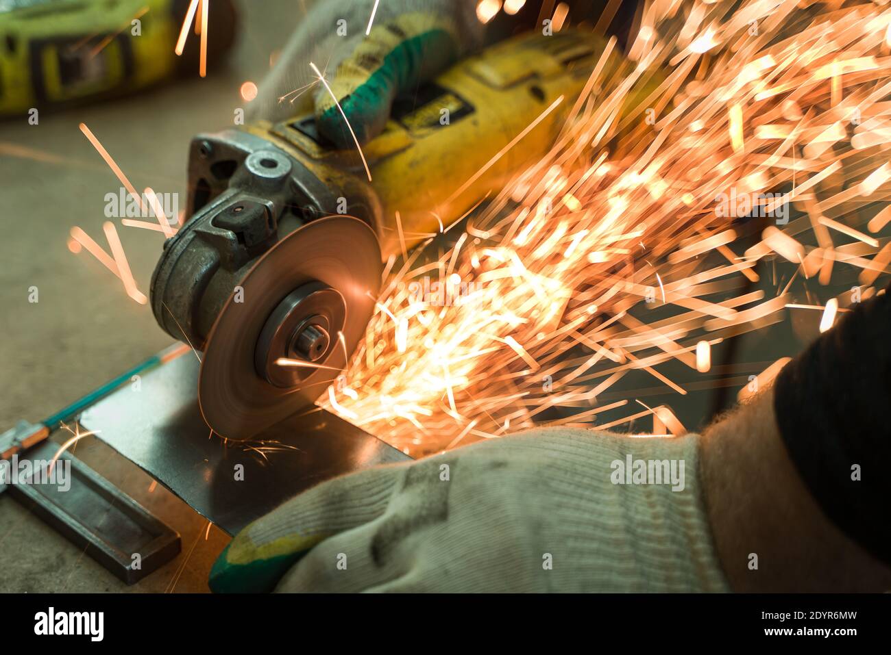 Locksmith in special clothes and goggles works in production. Metal ...