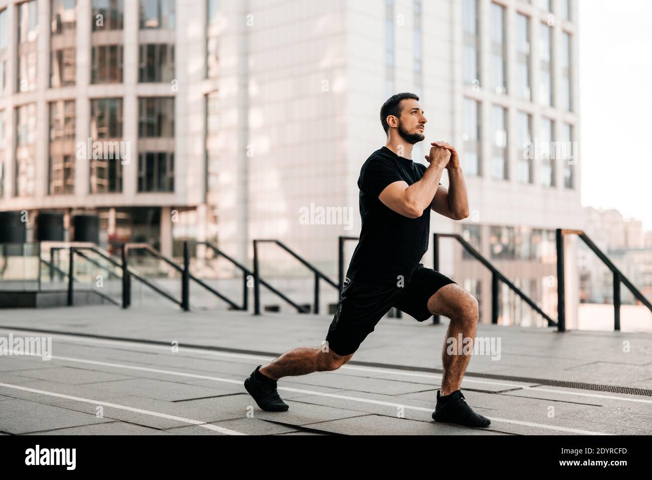 Fit man doing lunge forward. Sport in big city concept. Strong man ...