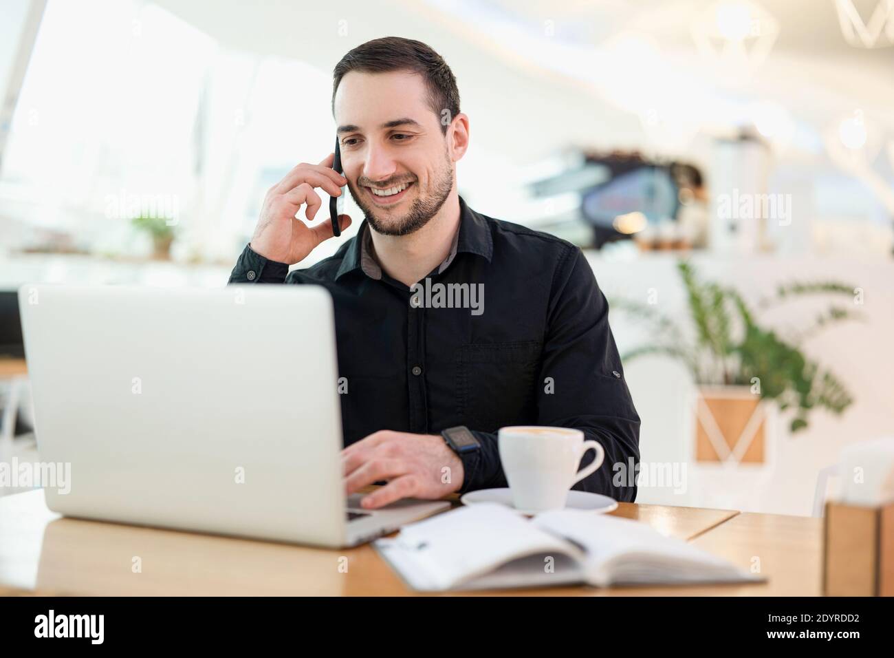 Succesful remote male worker. Young freelancer man happy with a phone ...