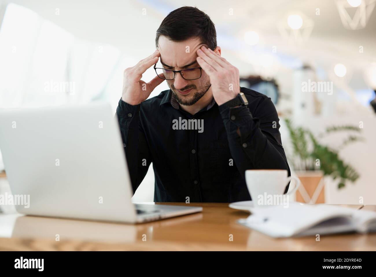It doesn't work Tired male programmer massaging temples, holding head ...