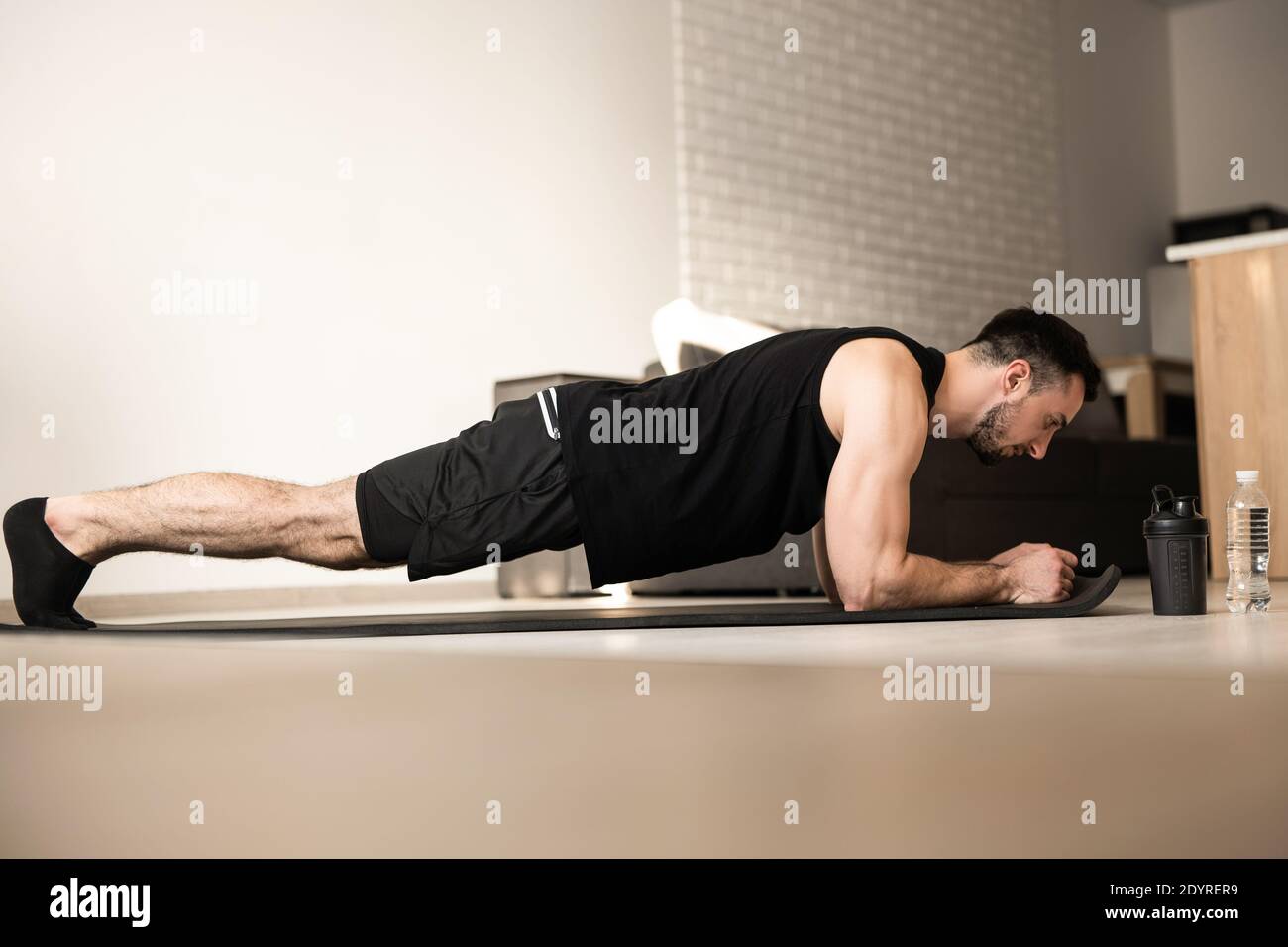 Plank it Training at home. Confident young man wearing black sportswear ...