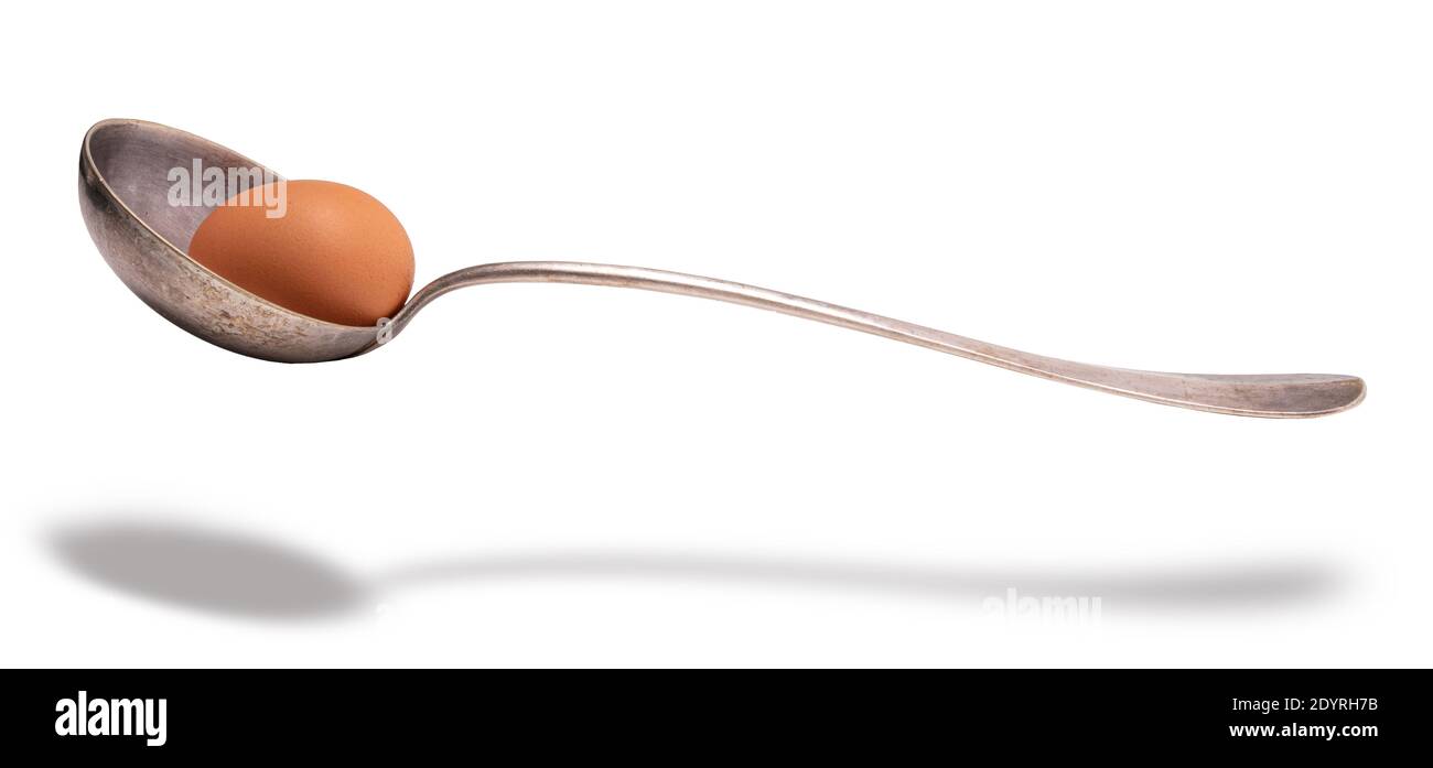 Silver ladle with an egg inside on a white background Stock Photo - Alamy