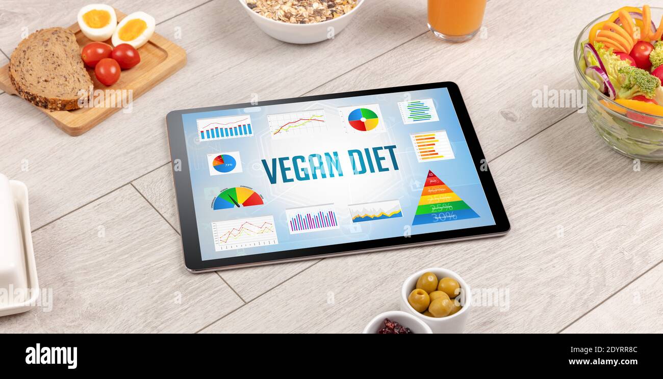 Organic food and tablet pc showing VEGAN DIET inscription, healthy ...