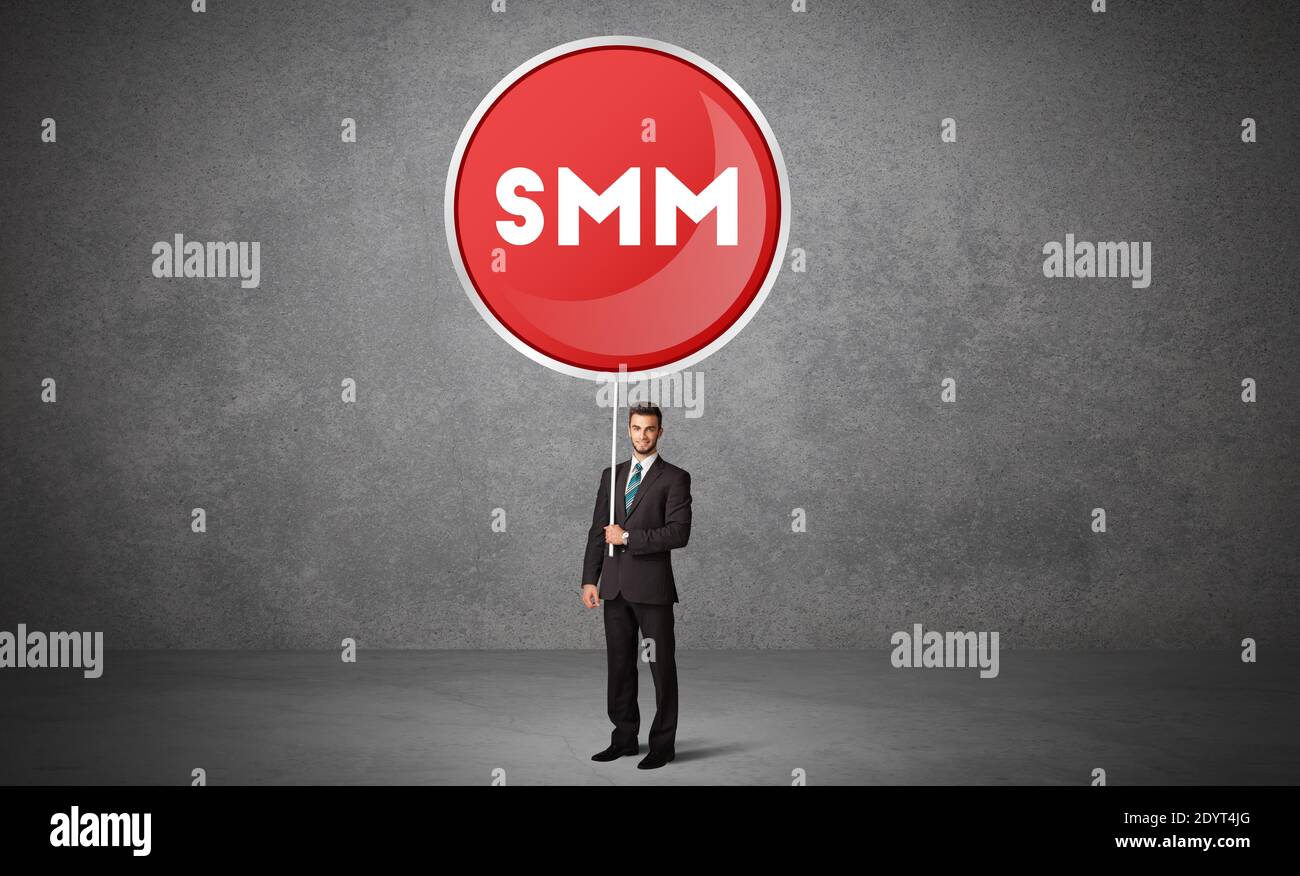 Young business person holdig traffic sign with SMM abbreviation ...