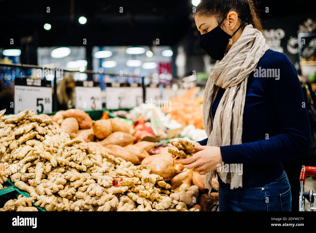 Young woman wearing protective face mask shopping in a supermarket ...