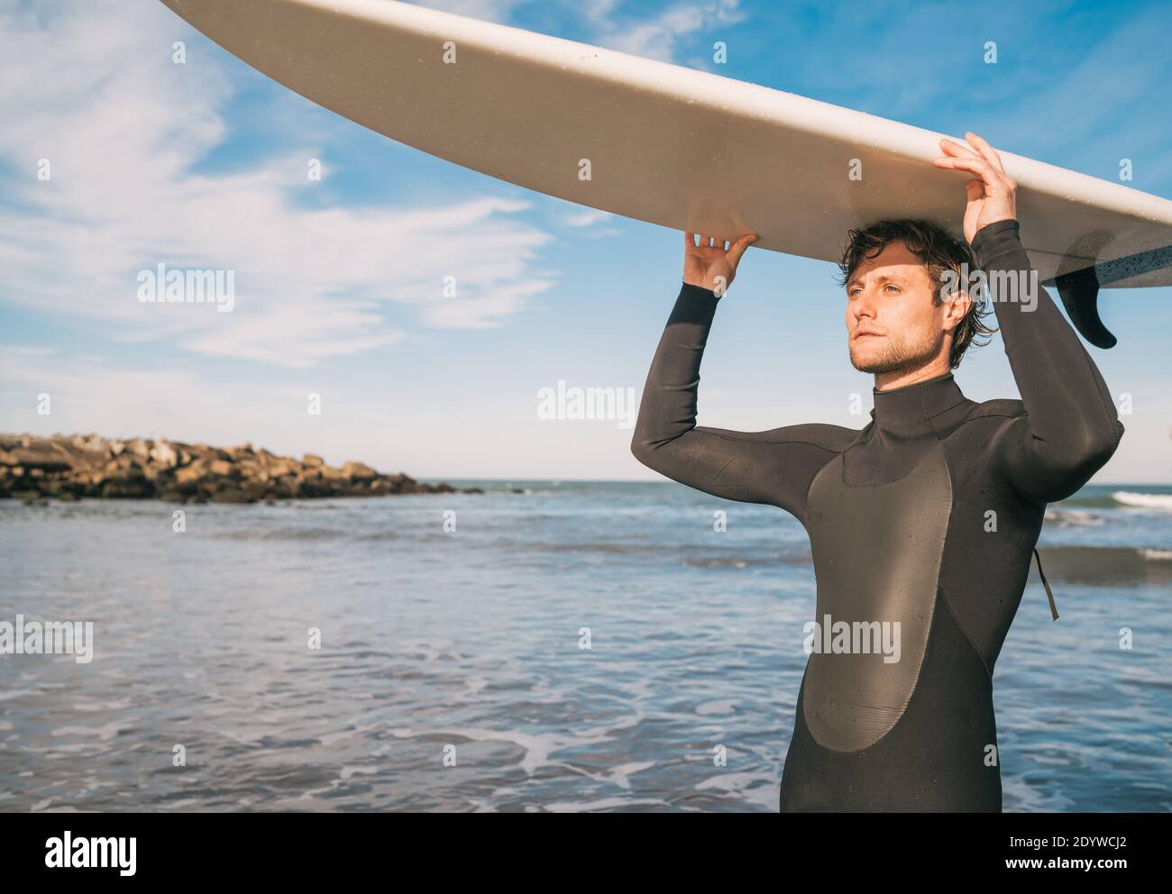 Young surfer holding up his surfboard Stock Photo - Alamy