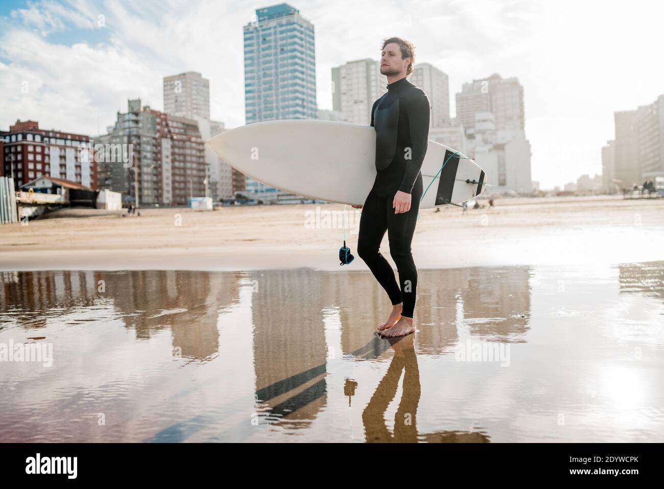 Surfer standing in the ocean with his surfboard Stock Photo - Alamy