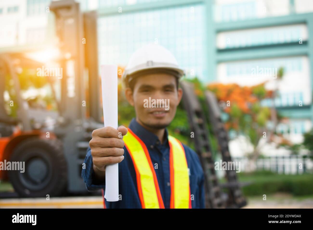 Engineering Holding Plan and wears a white safety hat while working ...