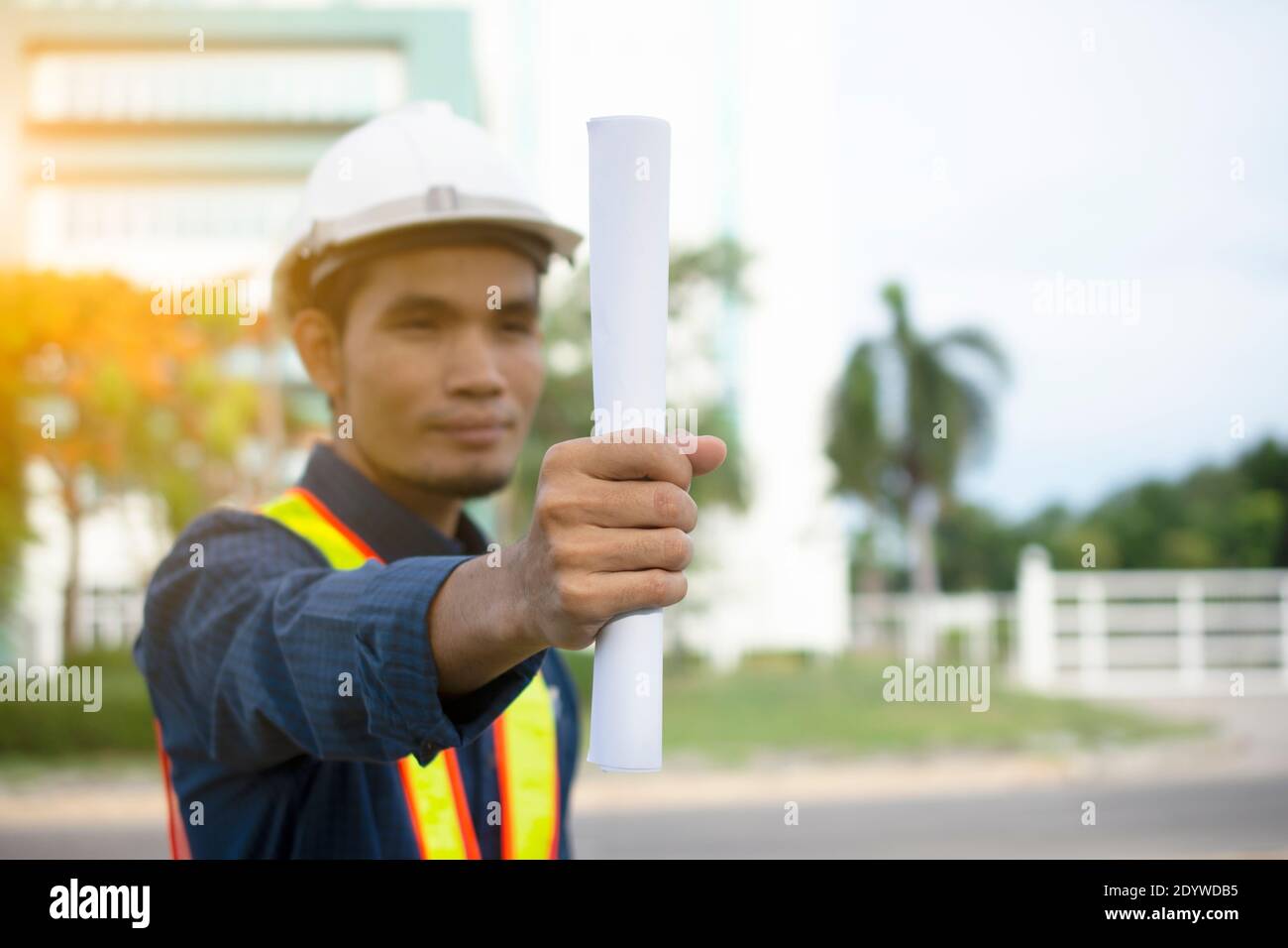 Engineering Holding Plan and wears a white safety hat while working ...