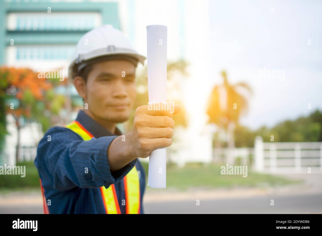 Engineering Holding Plan and wears a white safety hat while working ...