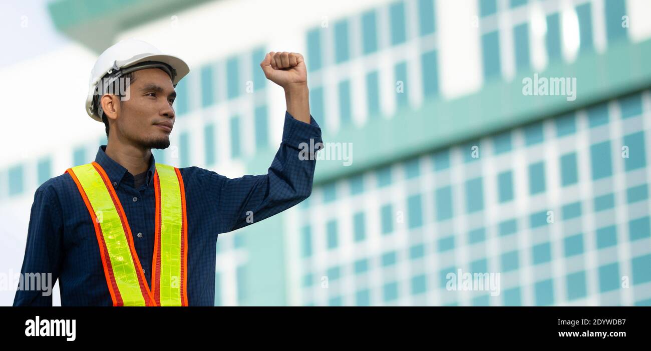 Engineering holding hand success and wears a white safety hat while ...