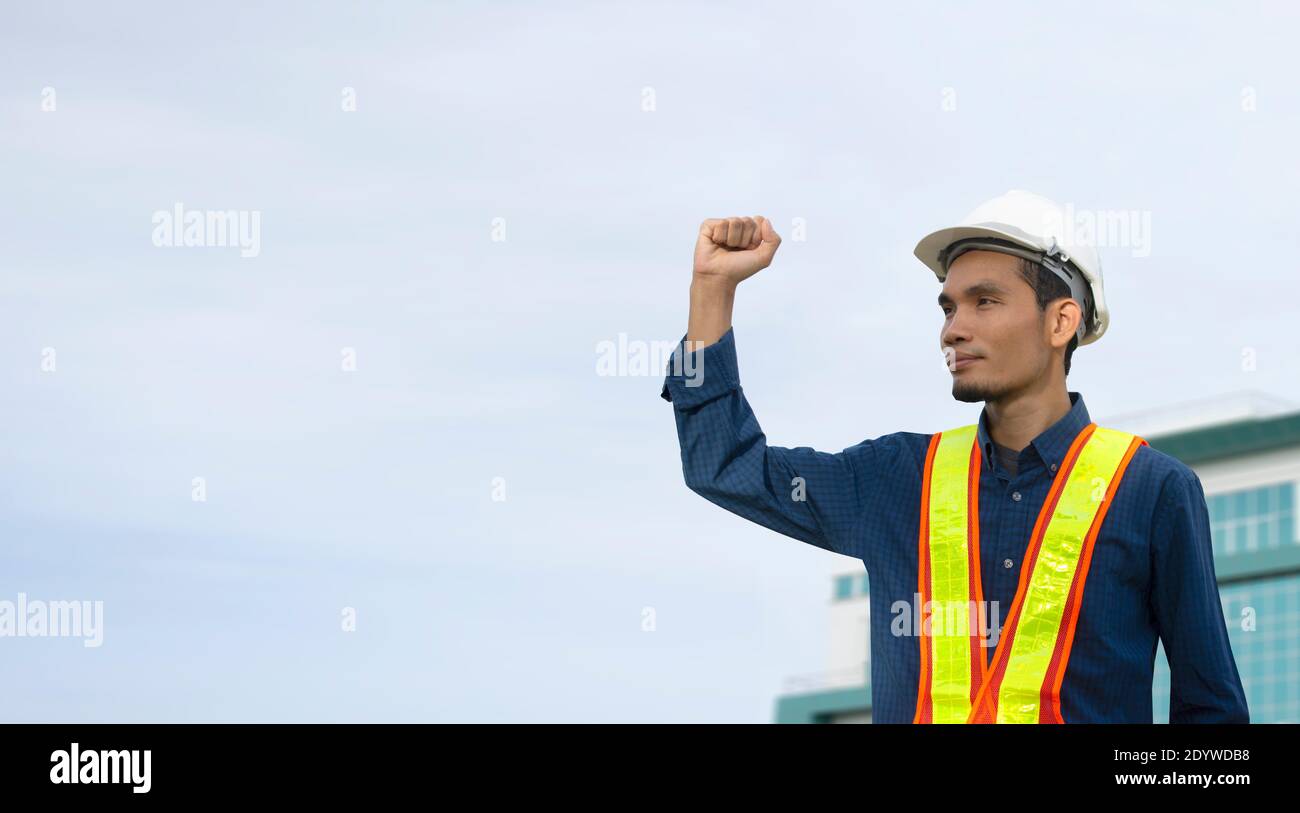 Engineering holding hand success and wears a white safety hat while ...