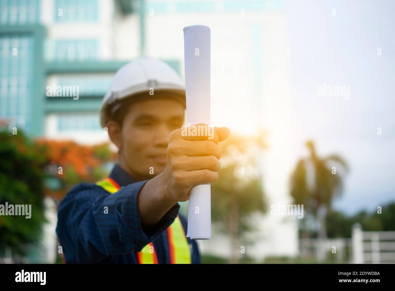 Engineering Holding Plan and wears a white safety hat while working ...