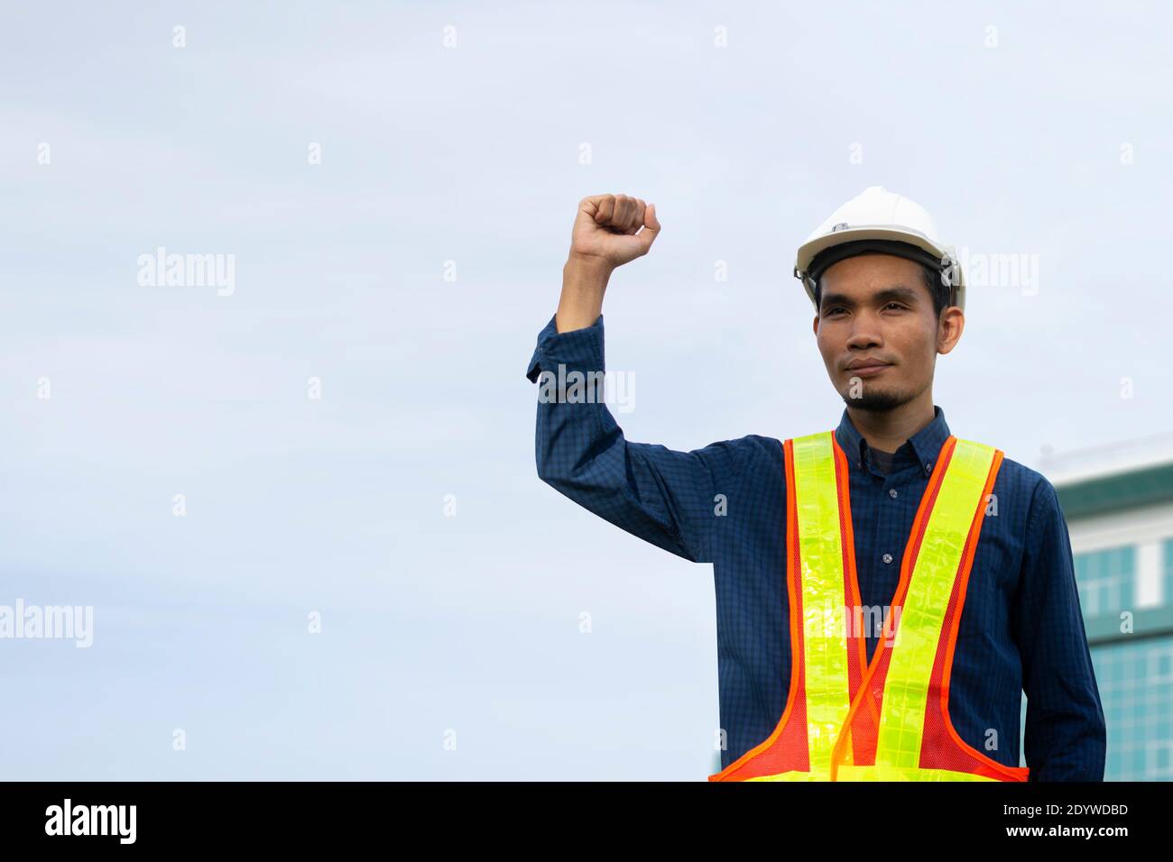 Engineering holding hand success and wears a white safety hat while ...