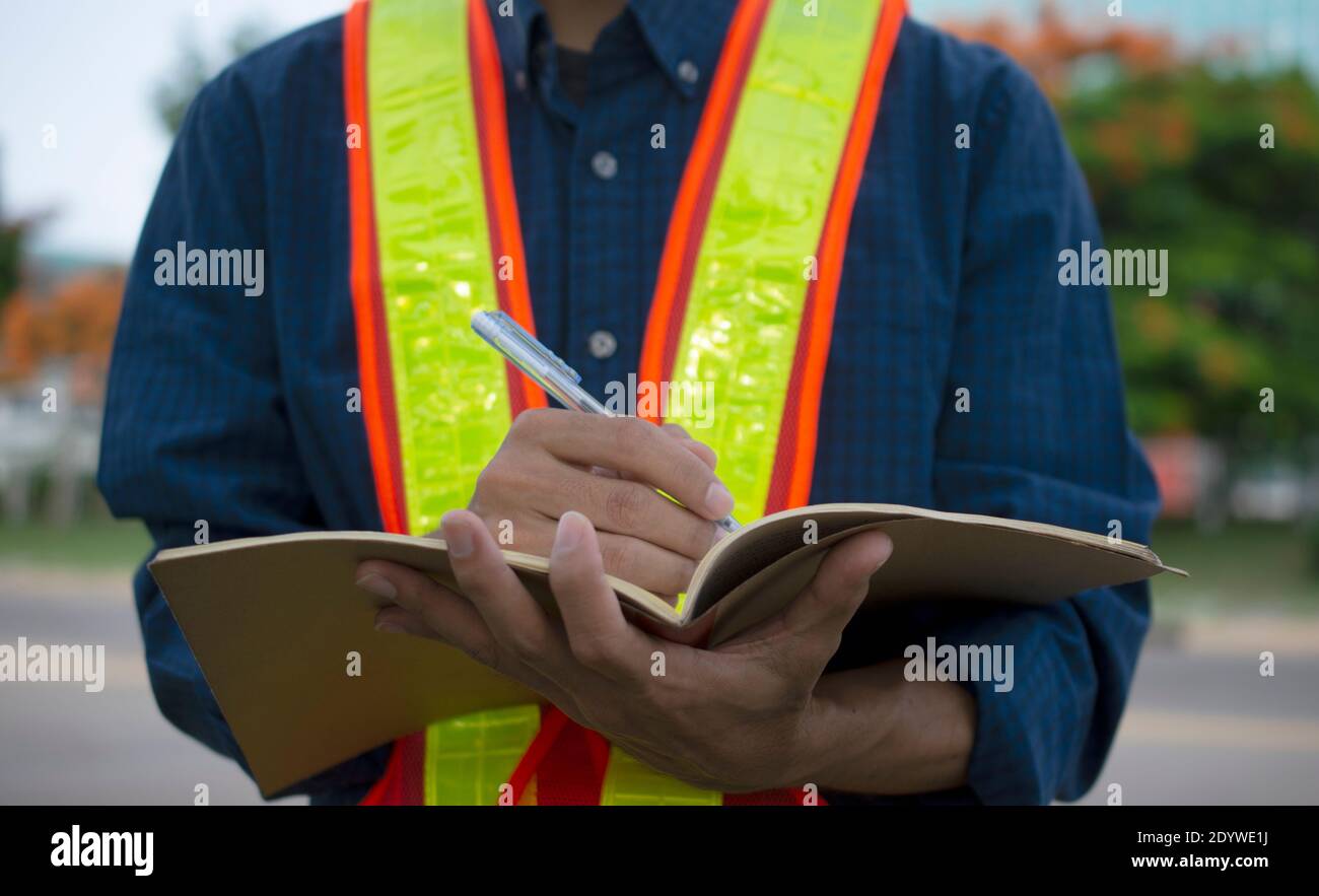 Engineer write take note on book for planing work Stock Photo - Alamy