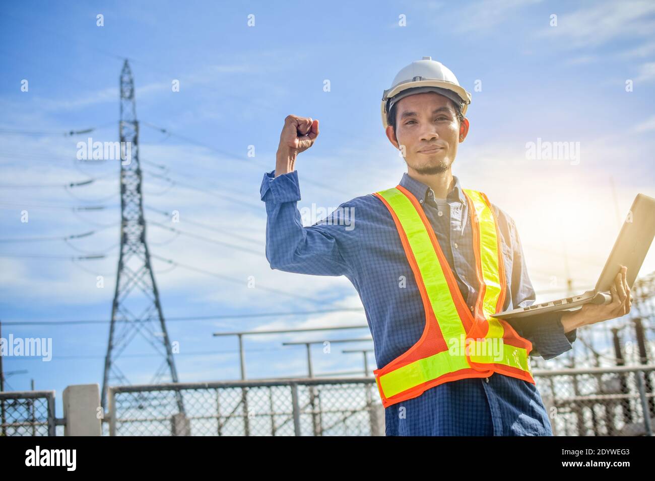 Engineer holding Computer notebook or laptop and a power plant with the ...