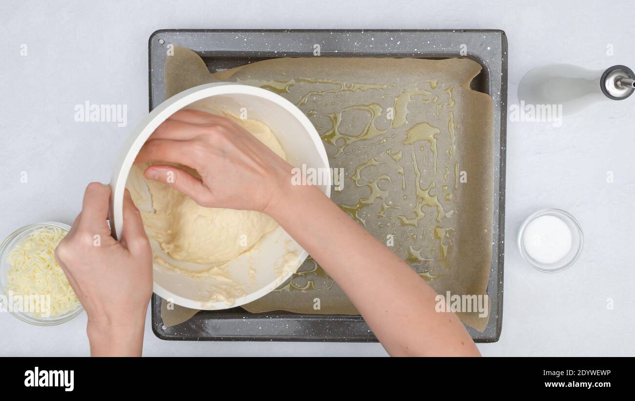 Chef puts bread dough on a baking tray. Cheese bread recipe, step by ...