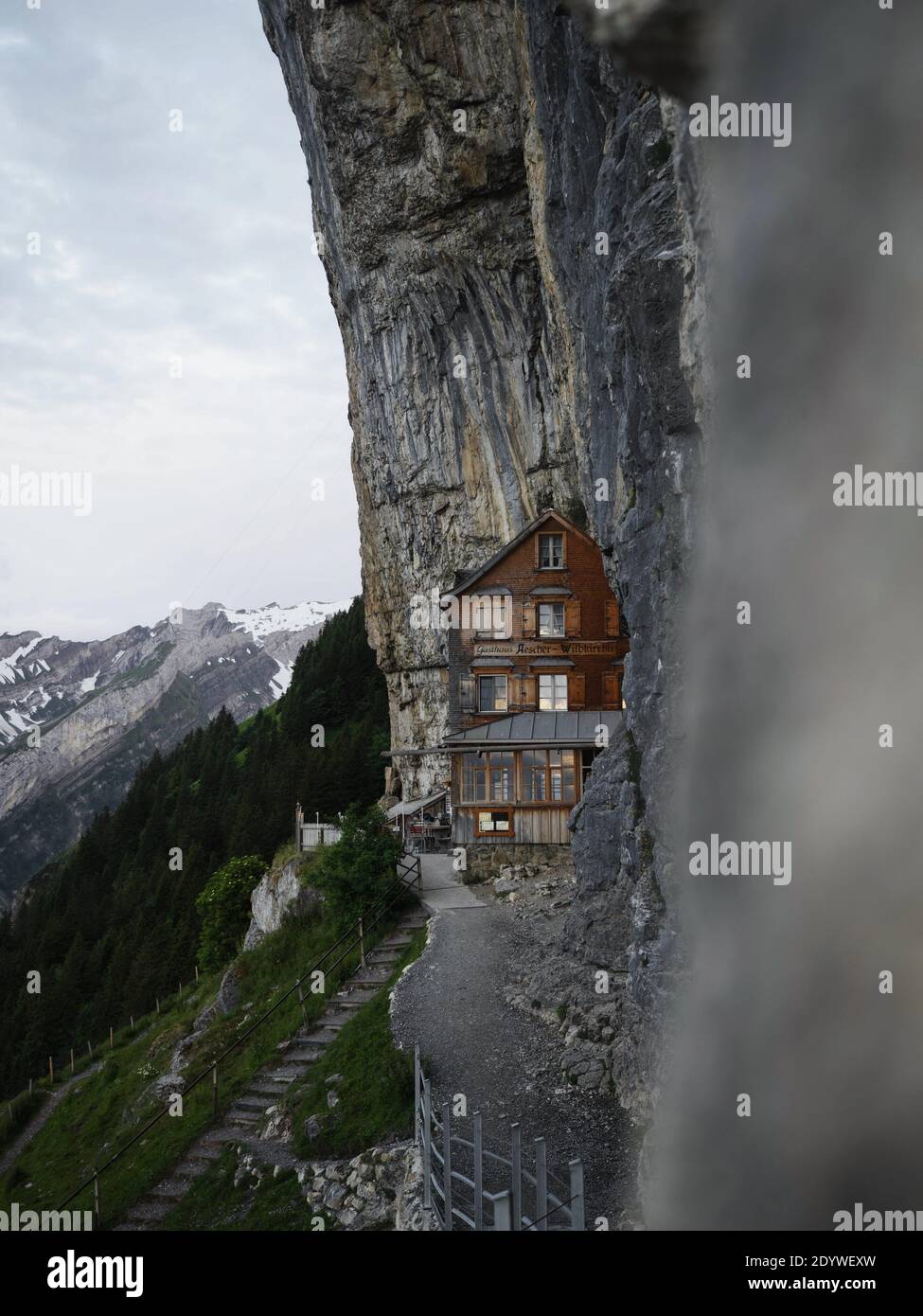 Famous guesthouse Aescher-Wildkirchli built into limestone cliff wall ...