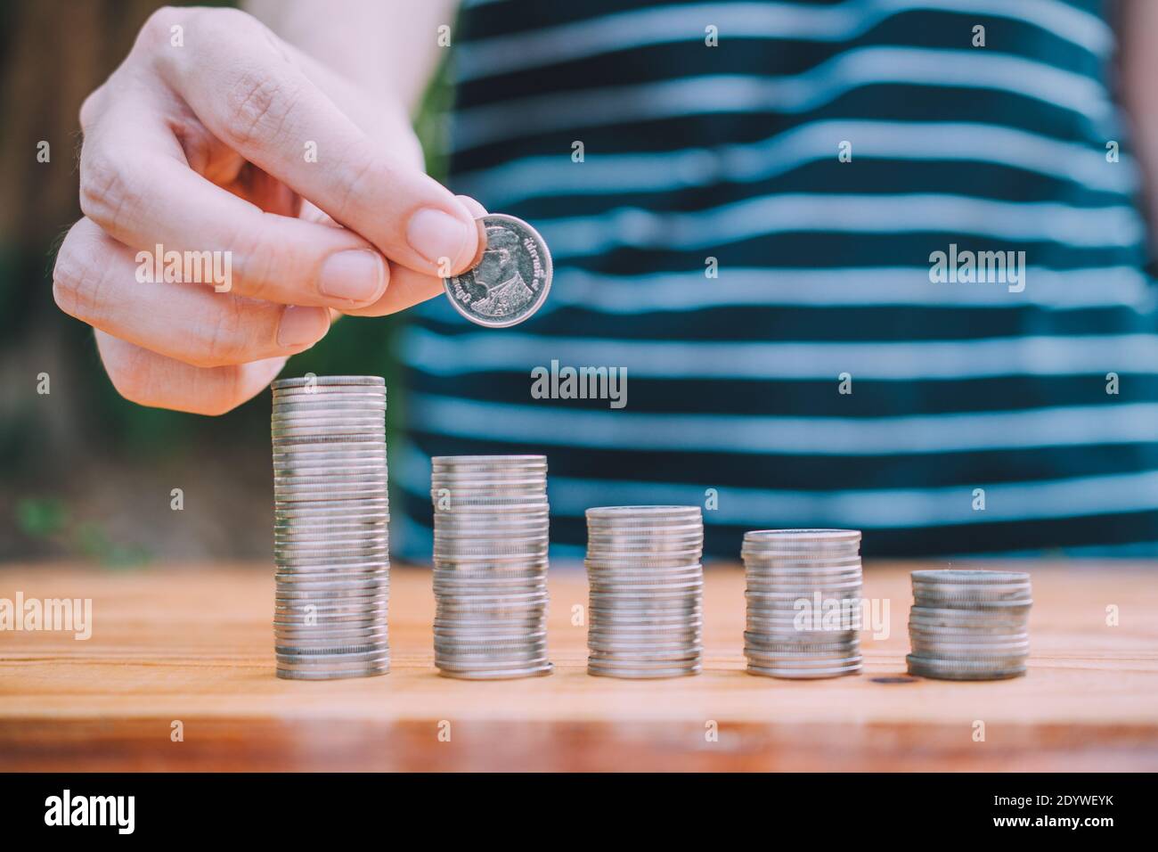 Hand holding coin and Coins stack on wood table money business finance ...