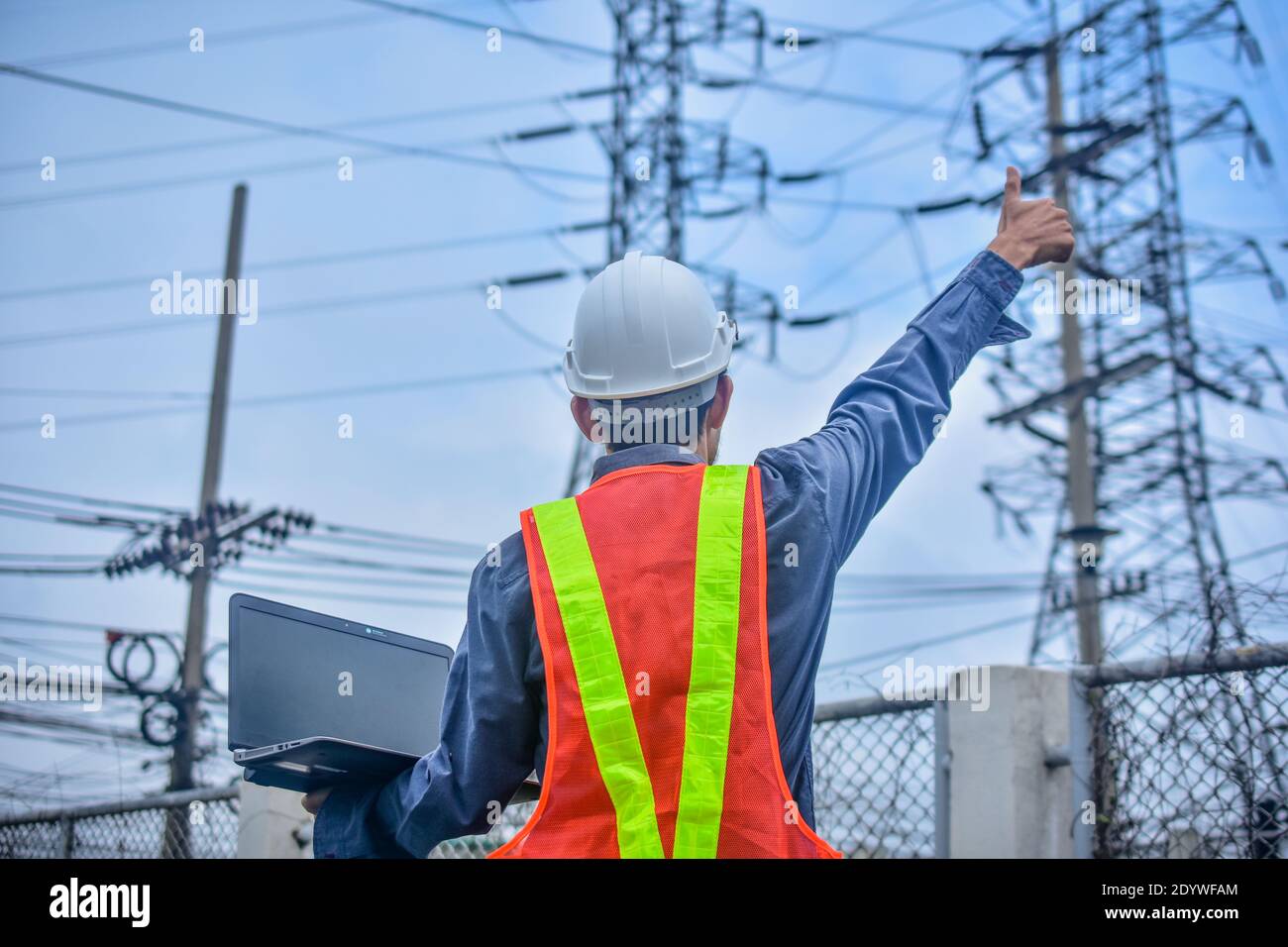 Engineer holding computer notebook high voltage power plant background ...