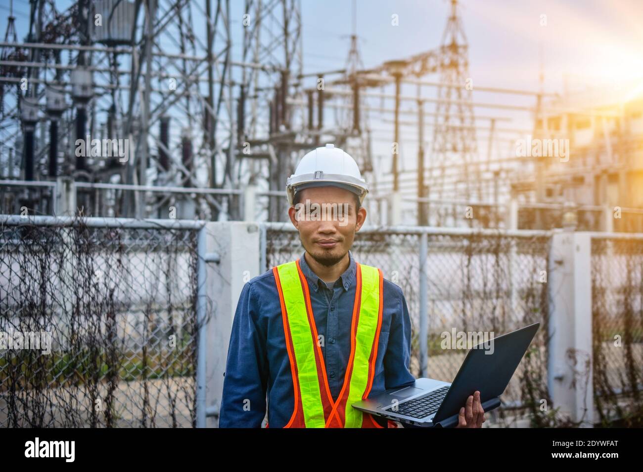 Engineer holding computer notebook high voltage power plant background ...