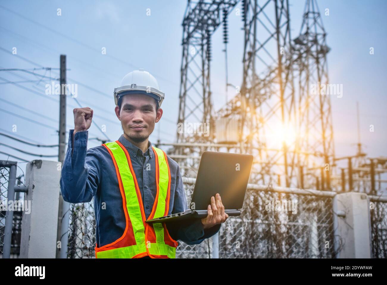 Engineer holding computer notebook high voltage power plant background ...