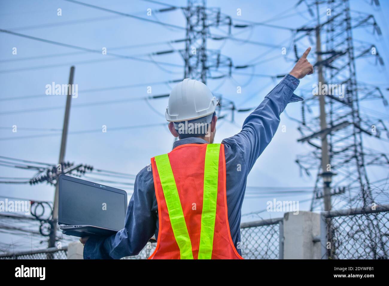Engineer holding computer notebook high voltage power plant background ...