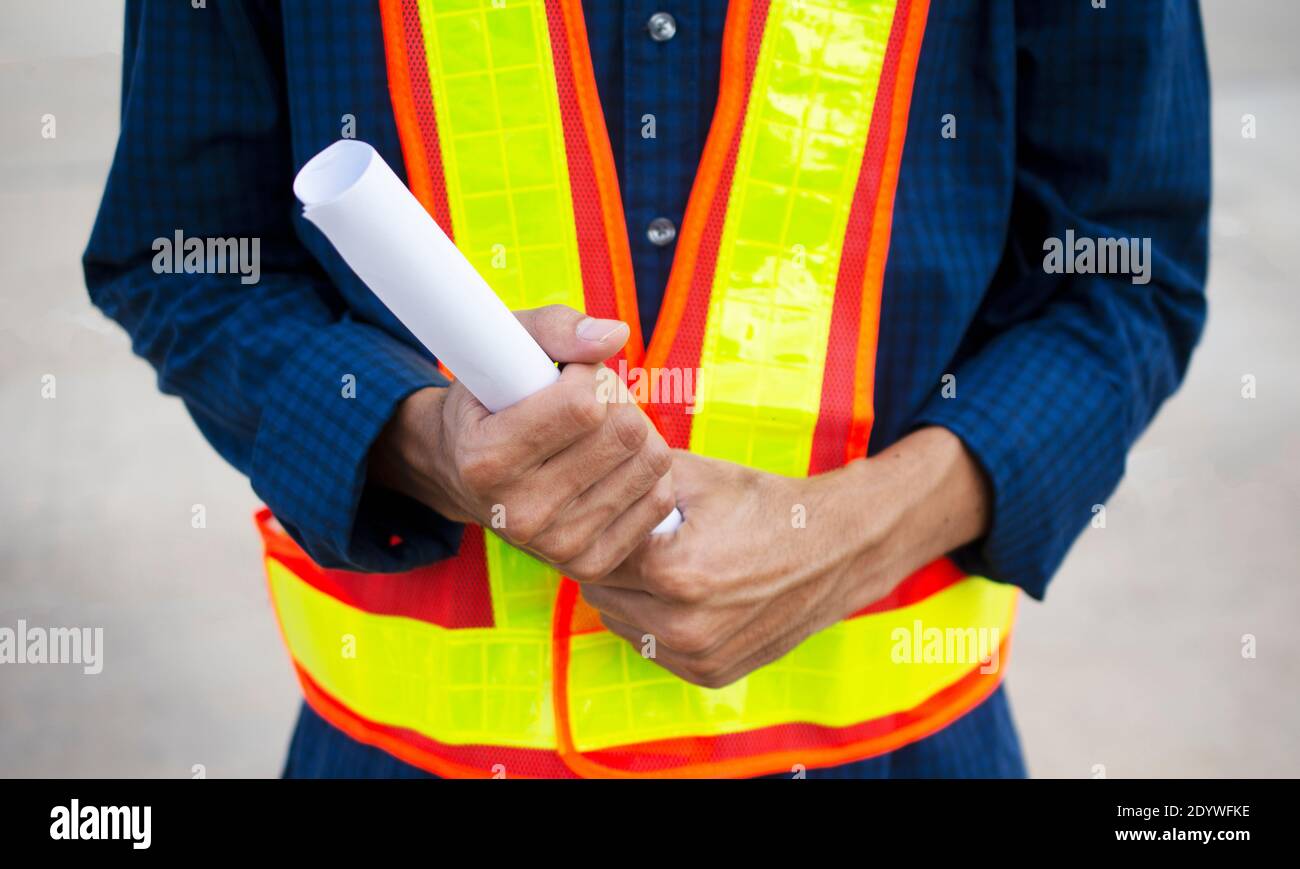 Engineer holding paper plan for planing st work Stock Photo - Alamy