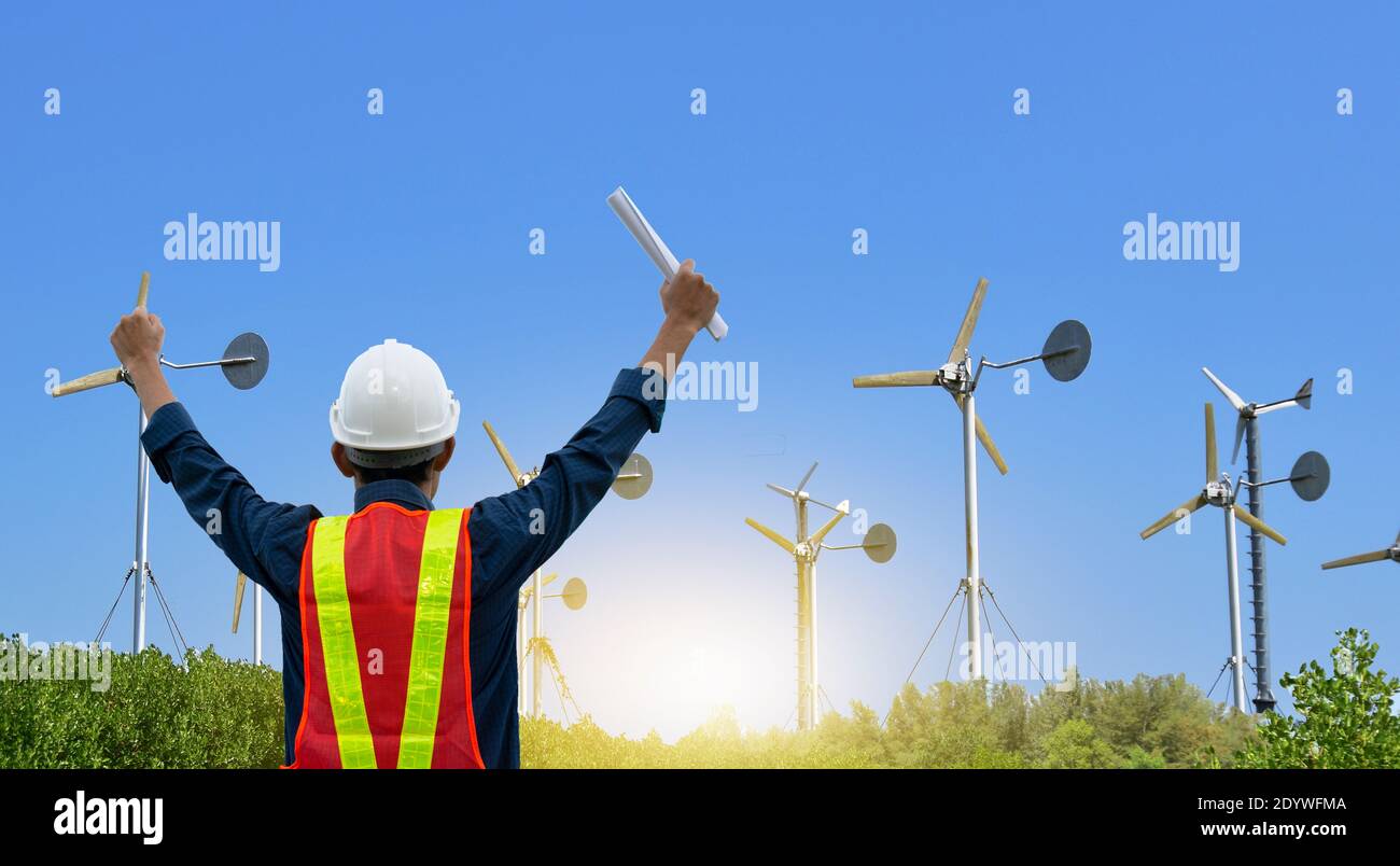 Engineer holding paper and Wind turbine electricity background ...