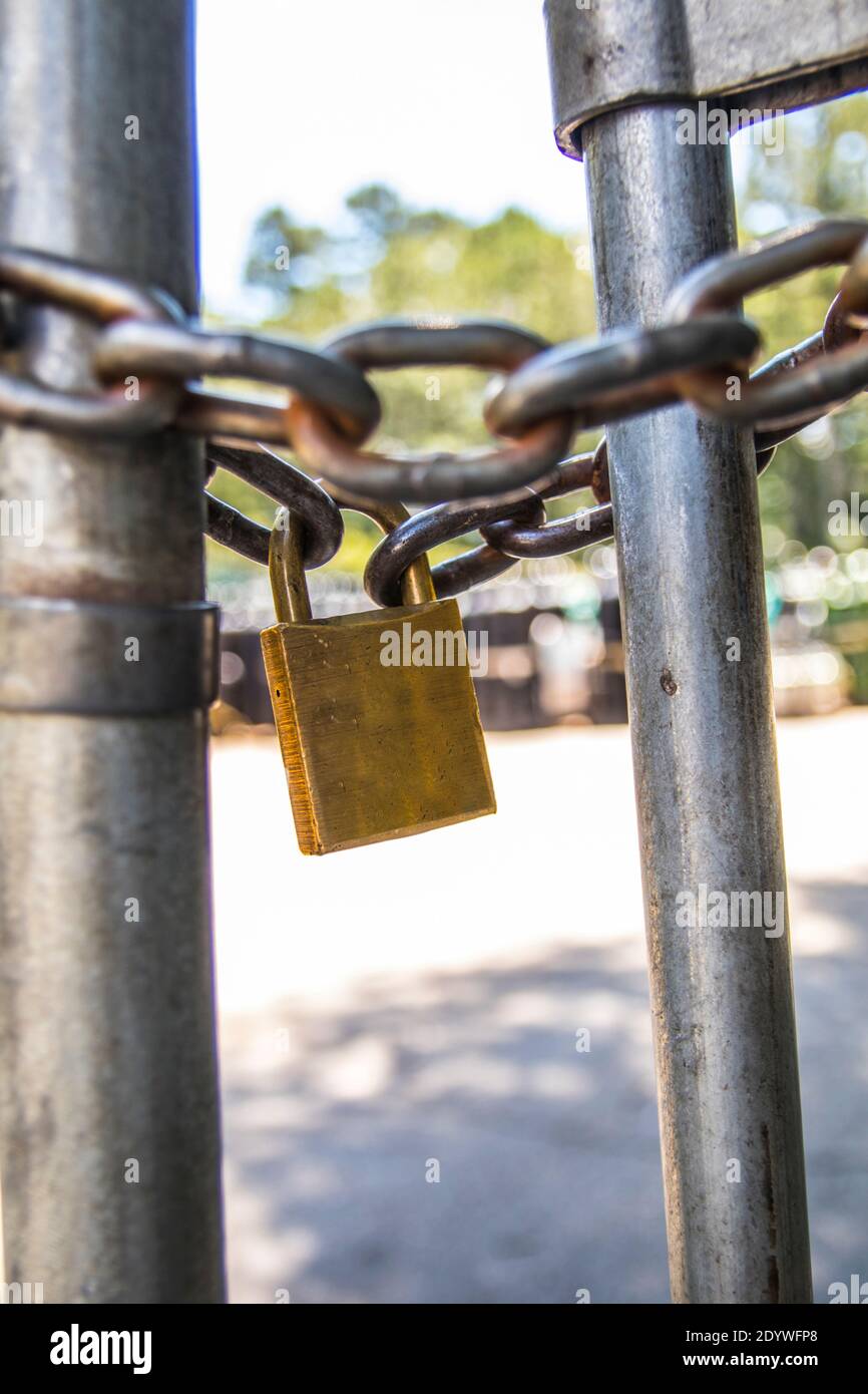 A padlock on a chain securing a gate entrance Stock Photo - Alamy
